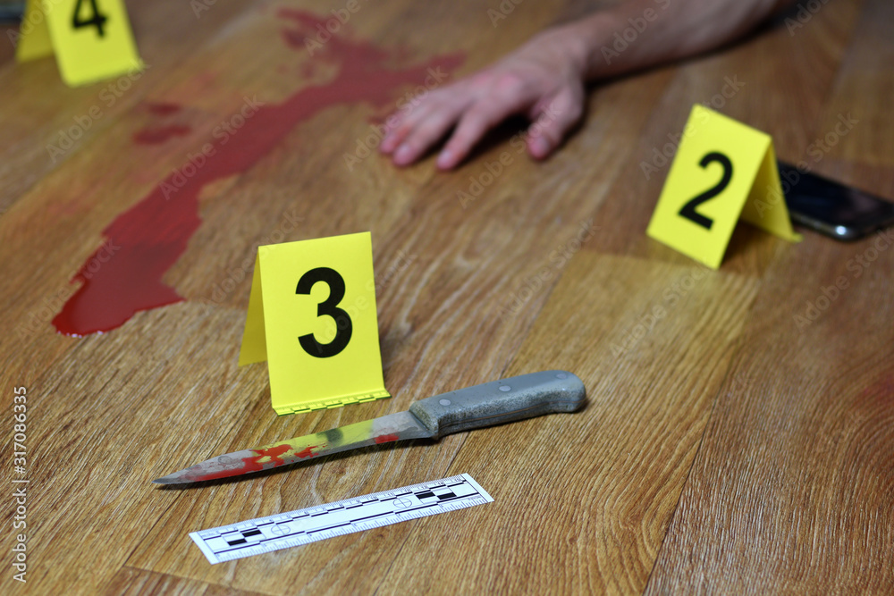 Crime scene investigation - Bloody knife and victims hand with yellow ...