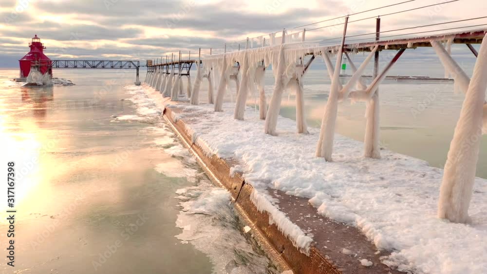 Moving drone view of ice covered pier and catwalk, with fascinating ice ...
