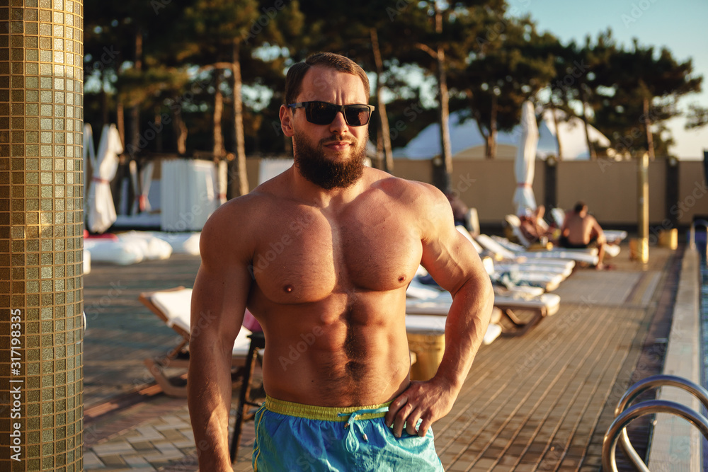Muscular man bodybuilder tanning in a beach club Stock Photo | Adobe Stock