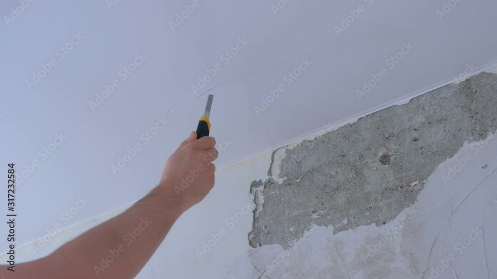 Process of dismantling of stretch ceiling cutting it using knife, hand ...