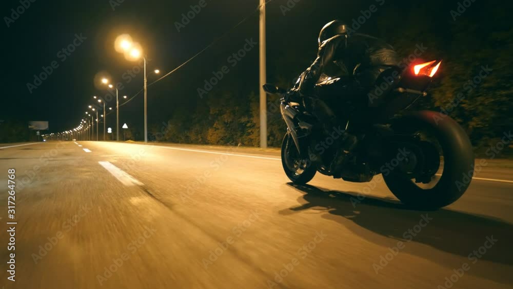 Man riding fast on modern sport motorbike at nighty city street ...