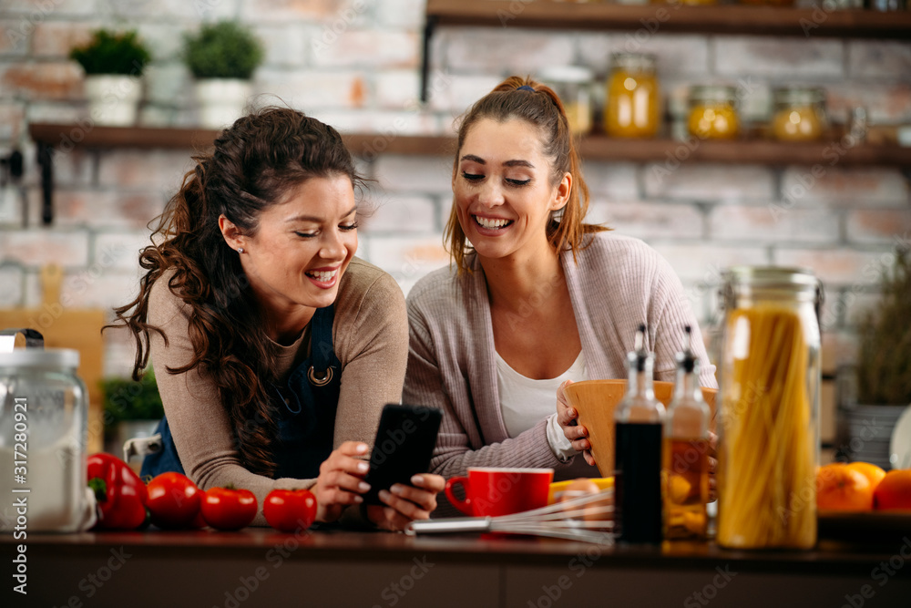 Sisters cooking together. Two friends having fun in kitchen. Stock ...