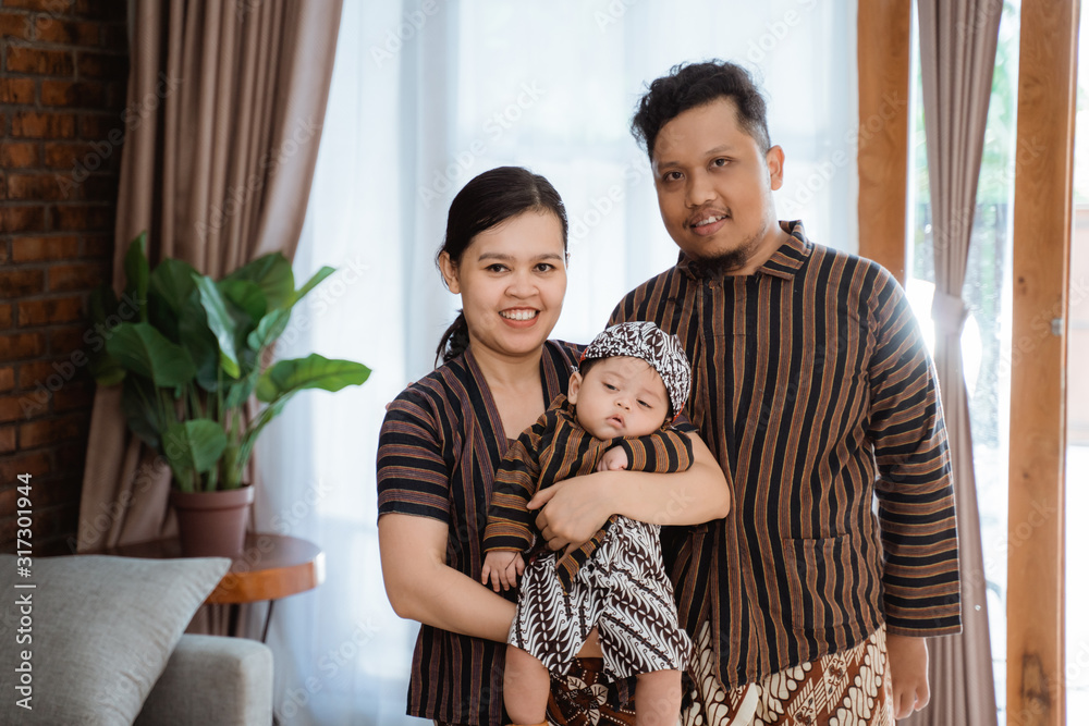 asian family wearing javanese batik with little son in the living room ...