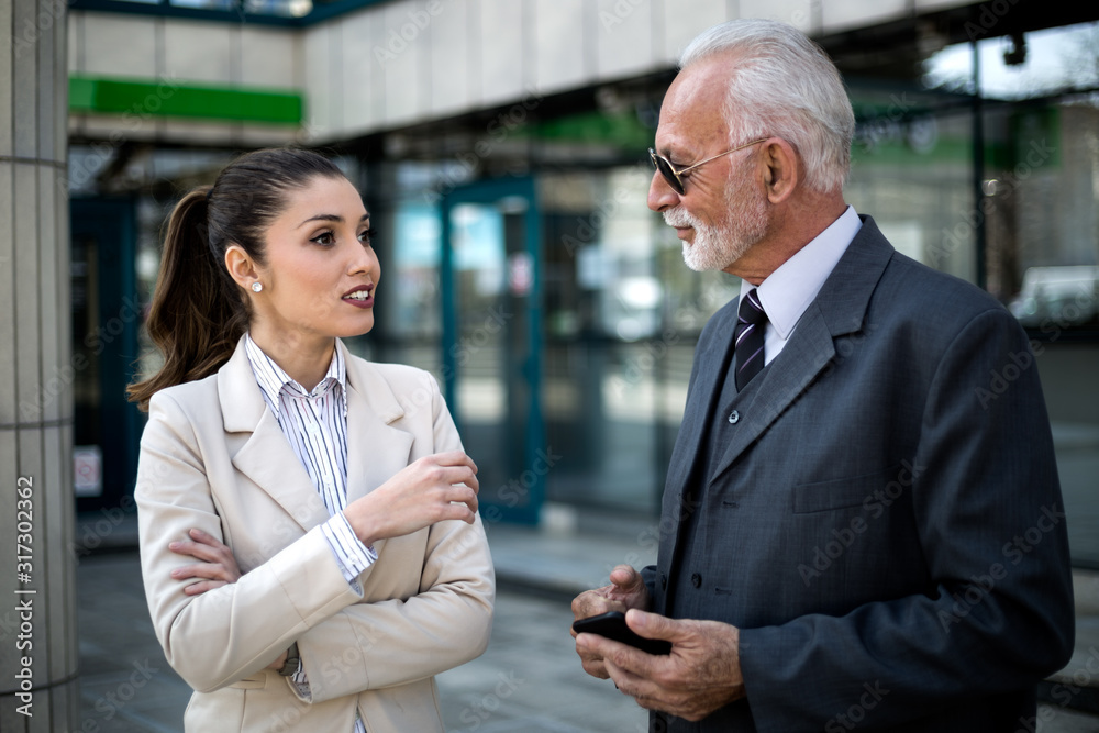 An older man and a young colleague are talking about work Stock Photo ...