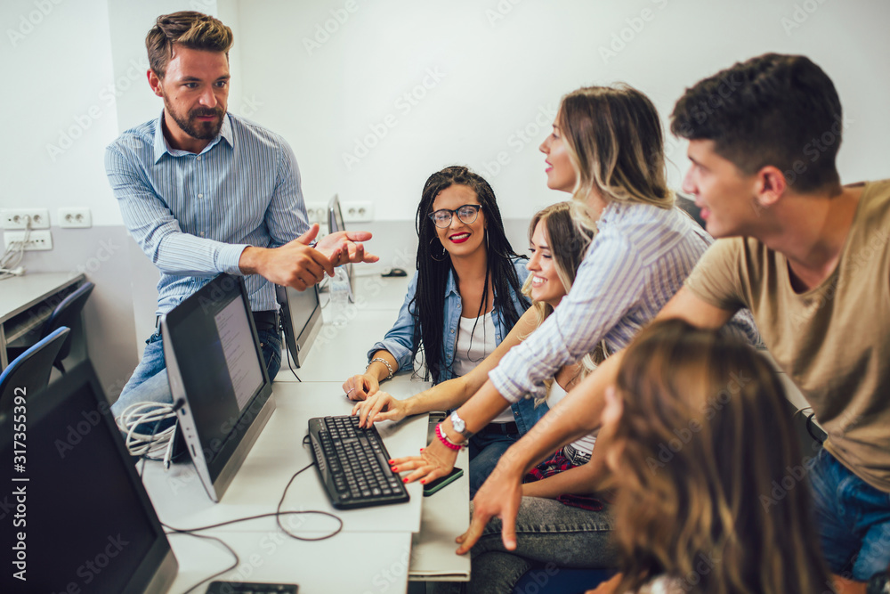 College students sitting in a classroom, using computers during class ...