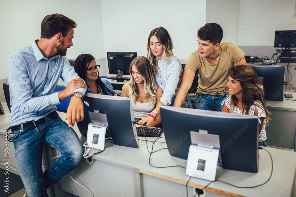 College students sitting in a classroom, using computers during class ...