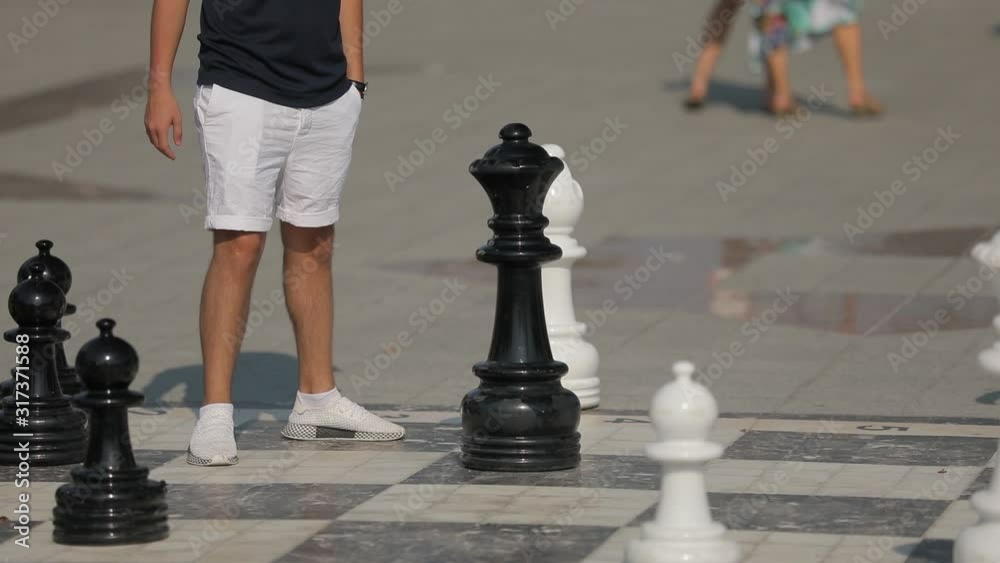 People play chess in the central square. They move huge chess pieces ...