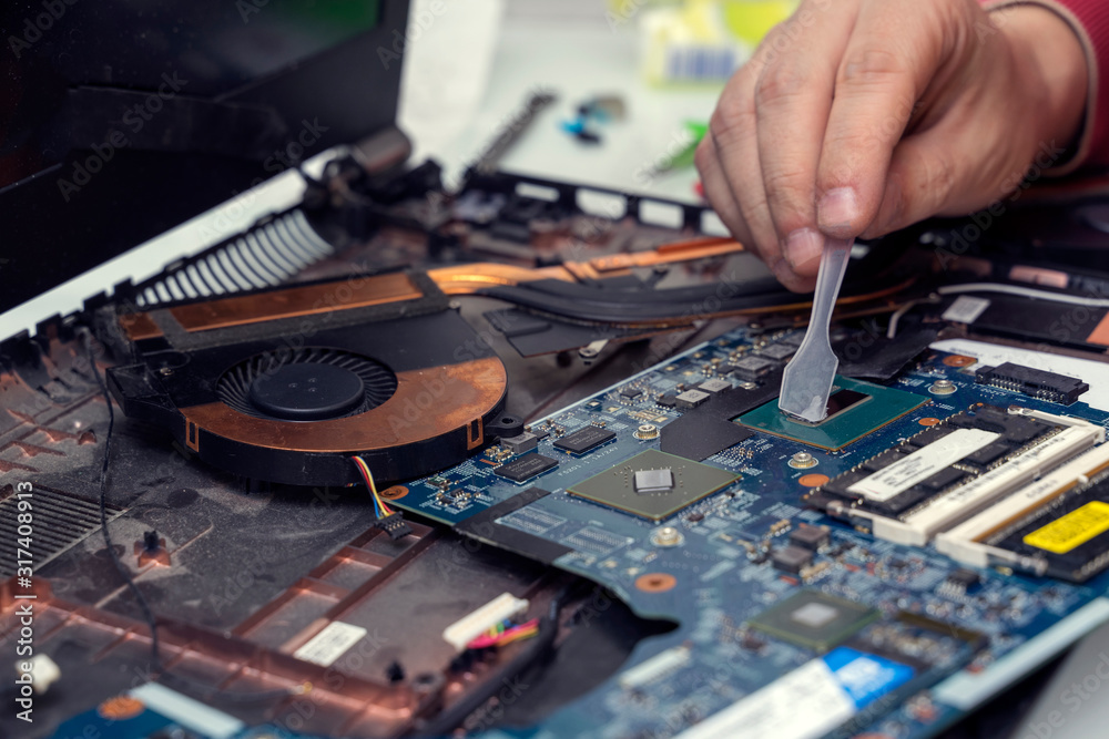 the master applies thermal grease to the computer processor. Computer ...