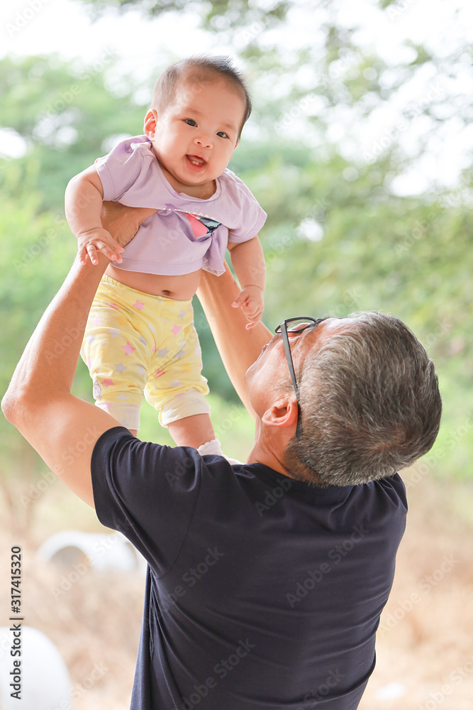 old man lift his cute baby and look at her smile, Use it for a child ...