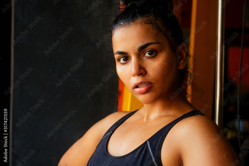 latin american fitness model in bra top and leggings looking tired with ...