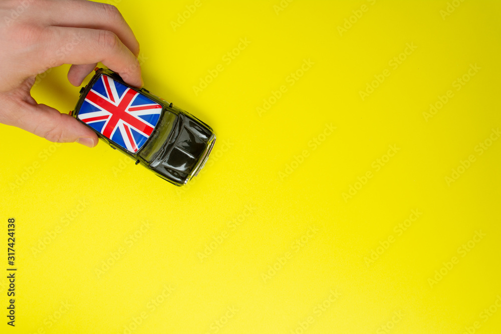 Classical English cab with british flags on the roof on the yellow ...