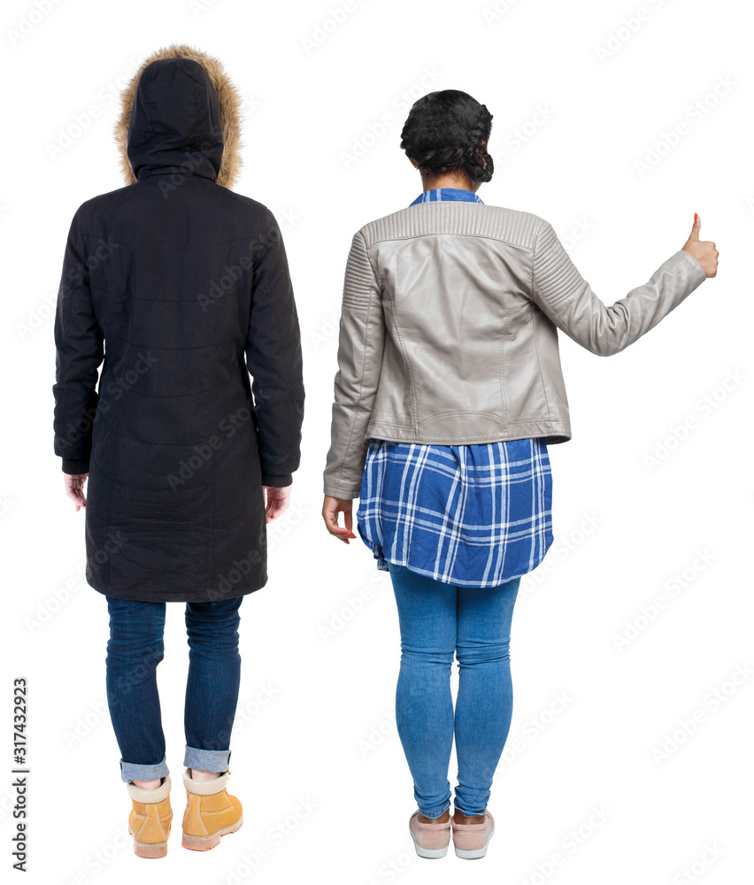 Back view of two young girl in winter jacket showing thumb up. Stock ...