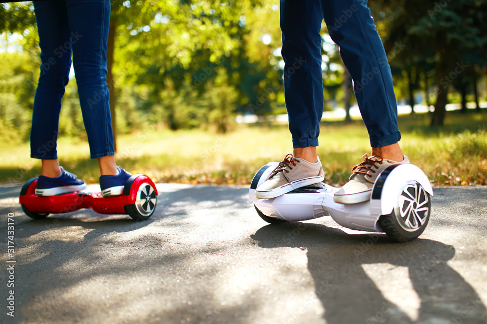 Legs of man and woman riding on the Hoverboard for relaxing time ...