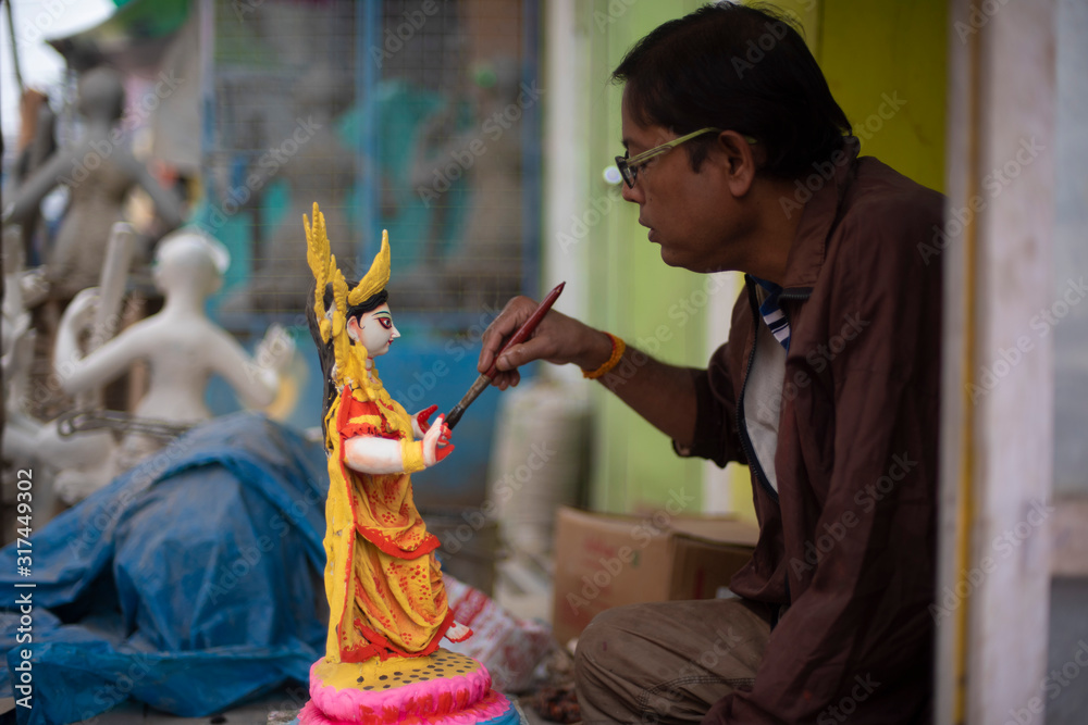Fotografia do Stock: An Indian artist making and painting clay idols of ...