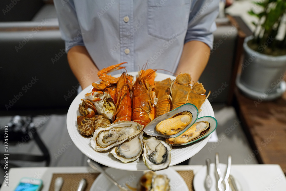 Plate of various types of seafood set, steamed rock lobster, baby ...