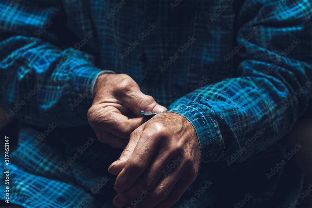 The old man fastens a button on the sleeve of his shirt Stock Photo ...