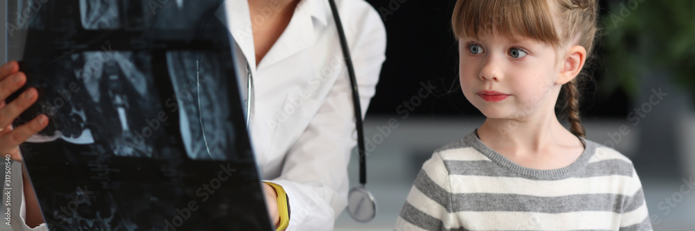 Child doctor specialist look x-ray image in hospital office portrait ...