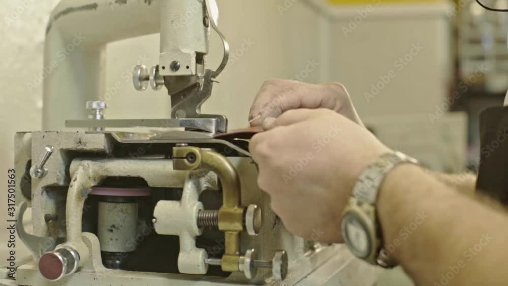 Industrial equipment in shoemaking factory. Hands of a worker working ...