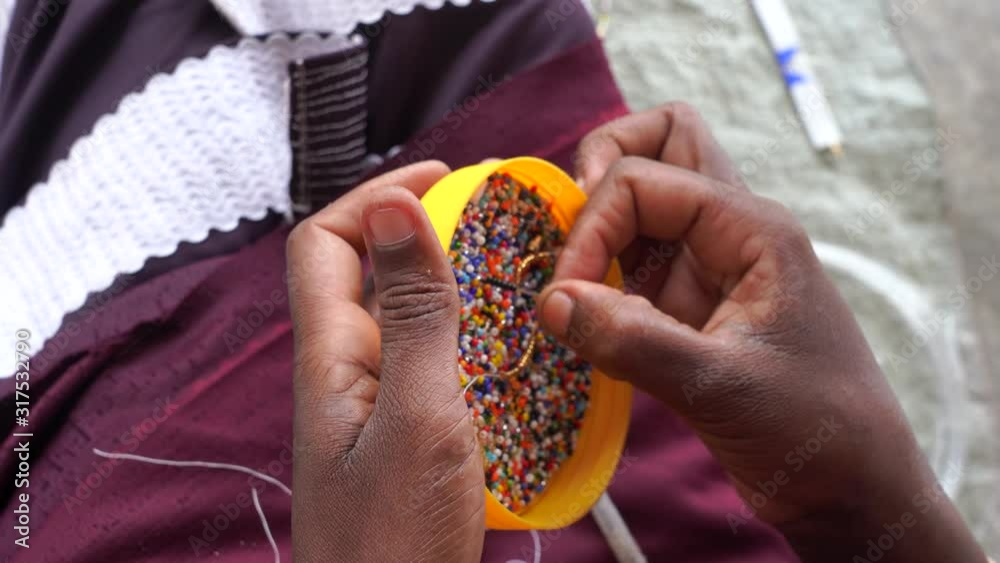 Making of handmade jewellery. Masai african women hands, top view ...