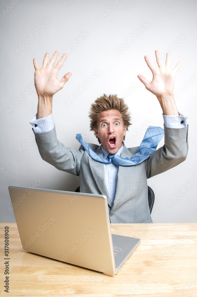 Shocked businessman falling back from his laptop computer working at ...