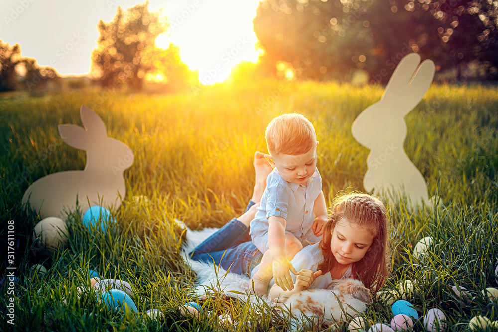 Little girl and boy play with the rabbit. happy little girl holding ...