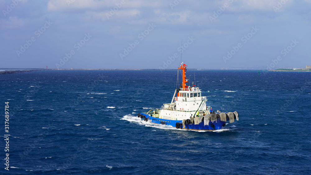 bright sea tug in the port of the Japanese city of Naha. Powerful ...