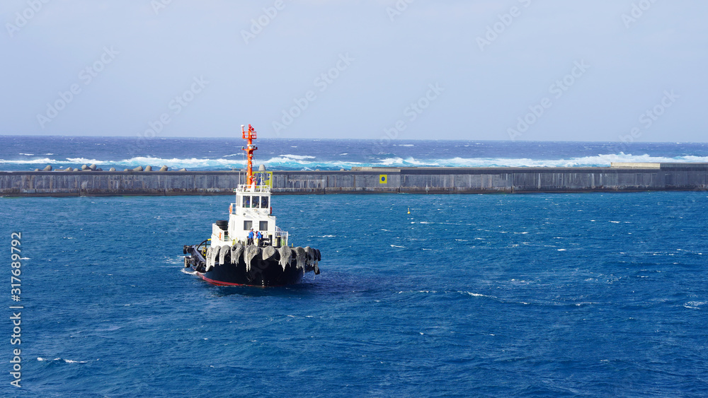 White towing ship in the ocean. A floating tow boat against a ...