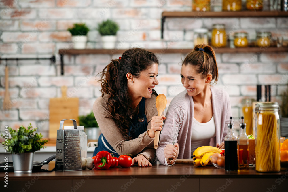 Two friends having fun in kitchen. Sisters cooking together. Stock ...