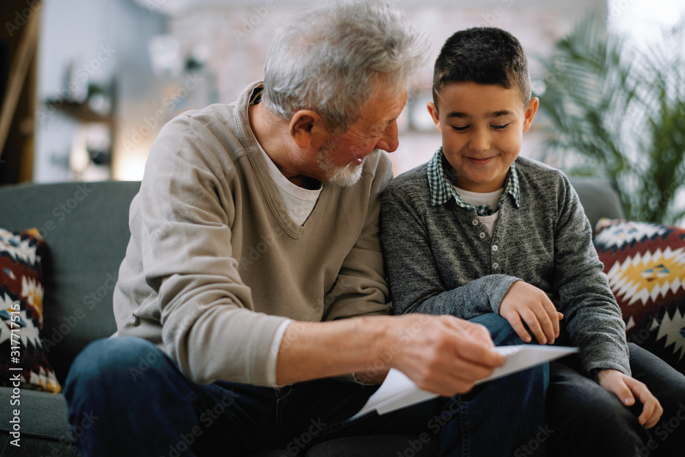 Grandfather teaching his grandson how to make paper airplane. Grandpa ...
