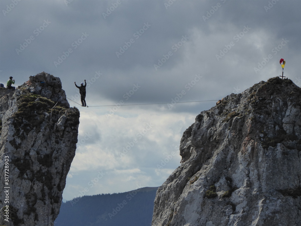 Practicing highline sports between rocky mountains, walking on a thin ...