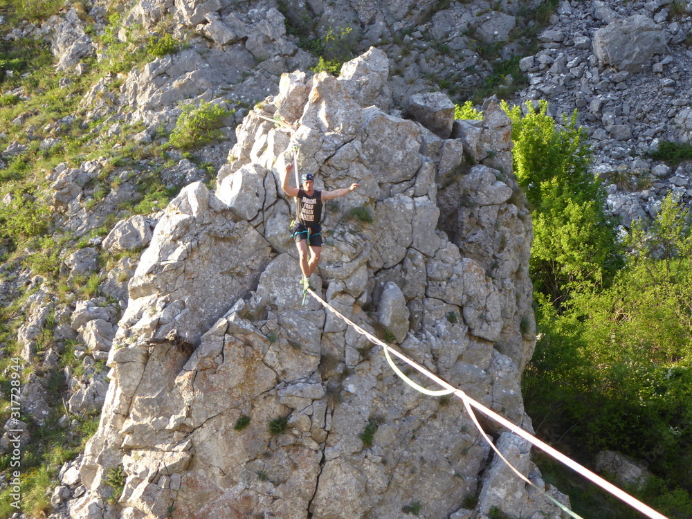 Practicing highline sports between rocky mountains, walking on a thin ...
