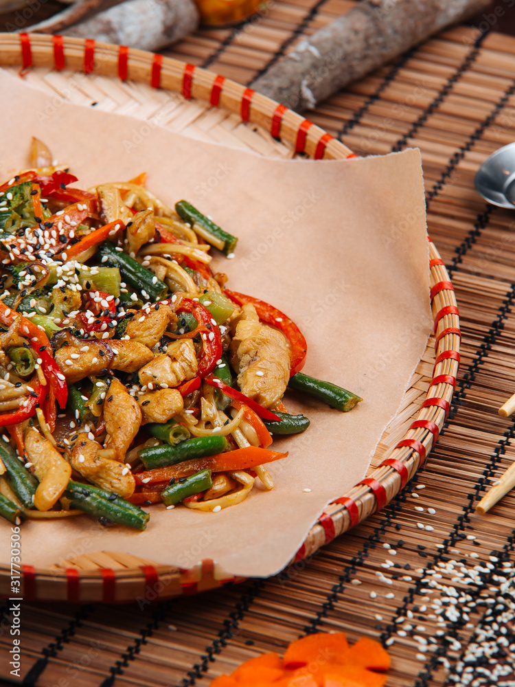 Thai chicken wok noodles. In a wooden plate. Prepared in a wok. Rice ...