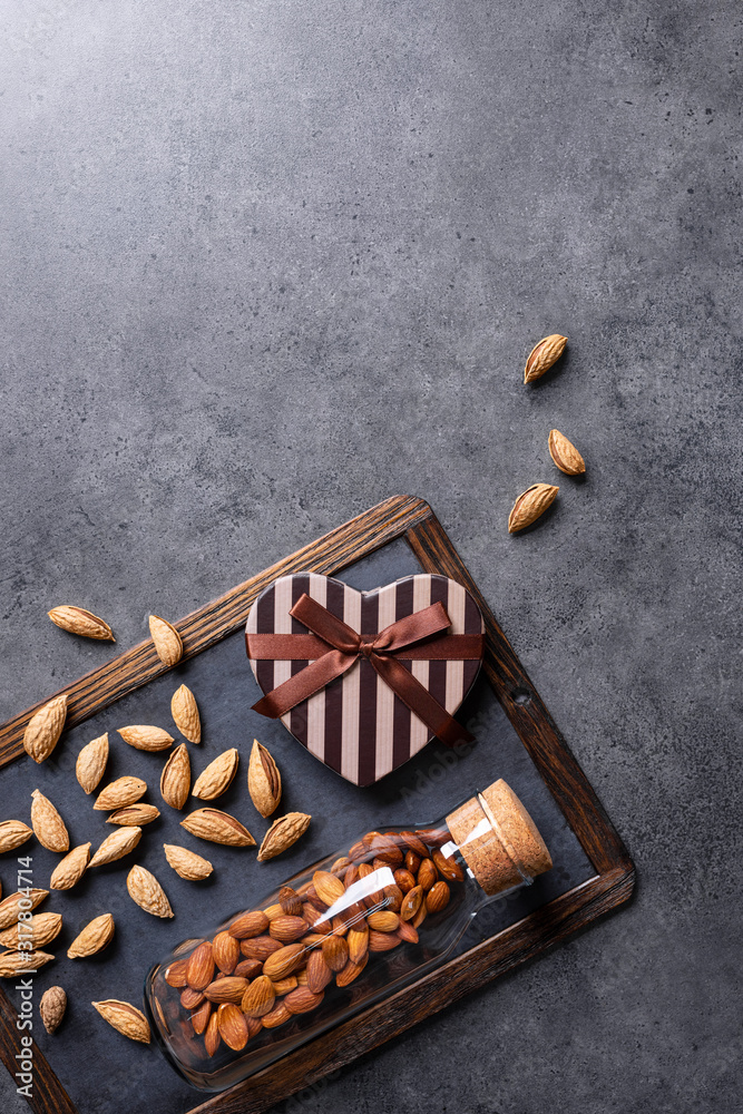 Heart shaped gift box with wild almonds around and almonds filled jar ...