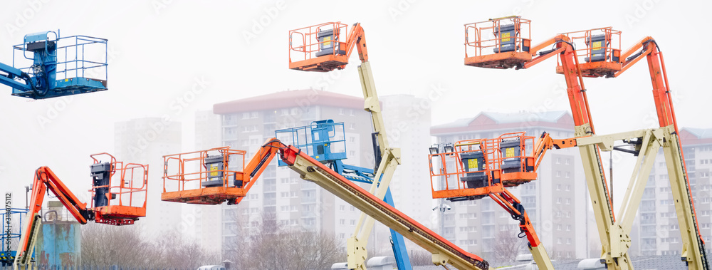 Access platform equipment powered high in sky in blue orange and yellow ...