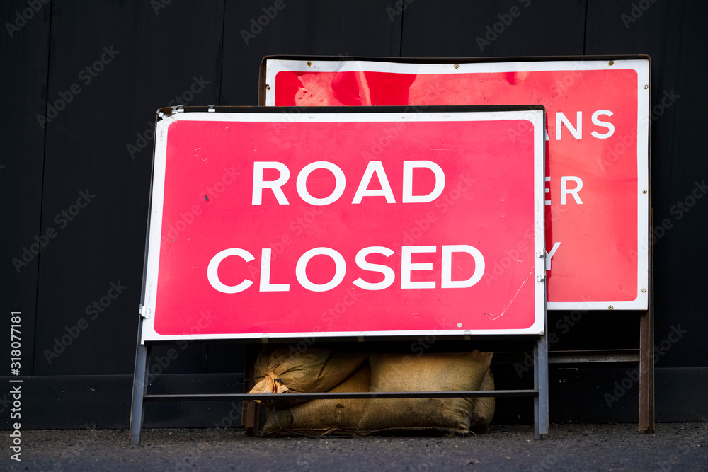 Road closed red sign and sand bags due to flood and surface water ...
