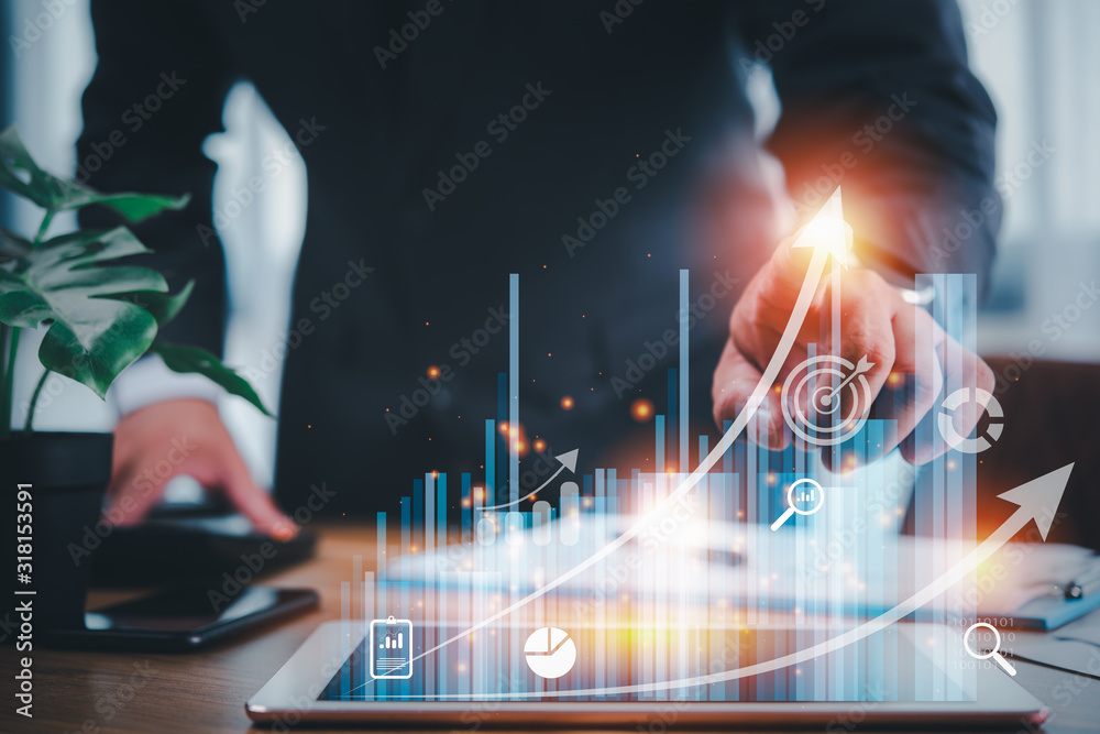 businessman using tablet analyzing sales data and economic growth graph ...