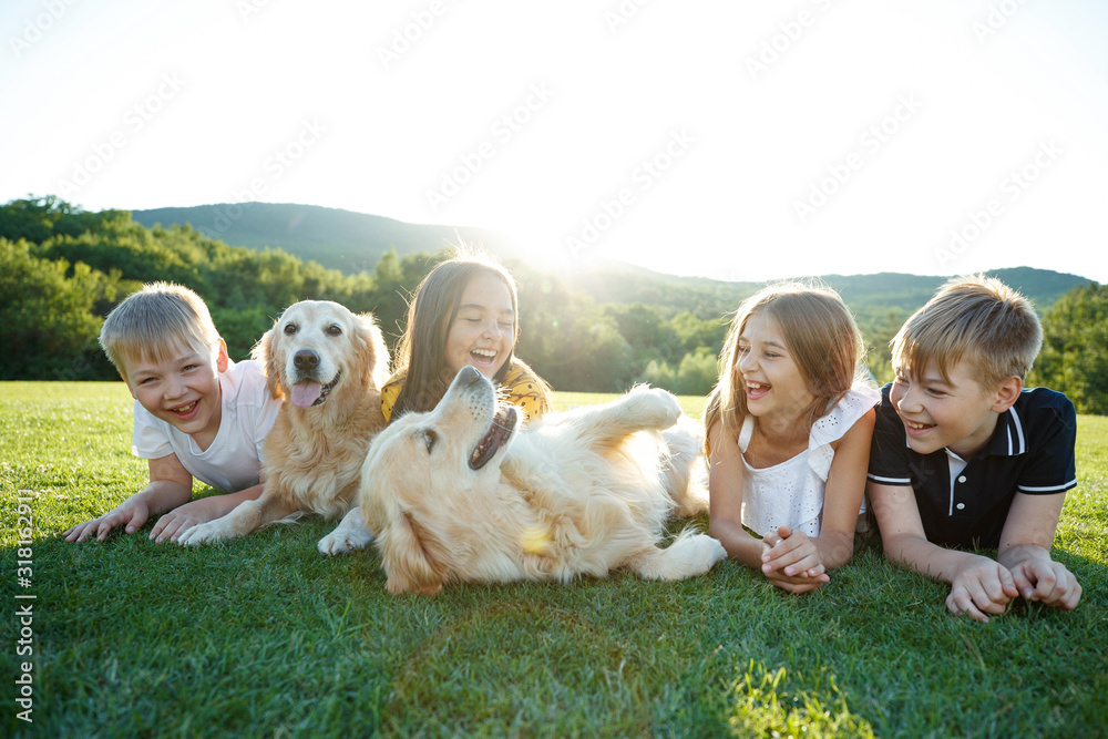 Children with a dog. A group of children are playing outdoors with a ...