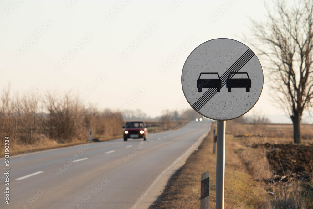 No passing sign. Circular white and grey sign. No more prohibited ...