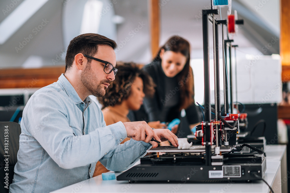 Engineer working on 3D model with 3D printer, side view, portrait ...
