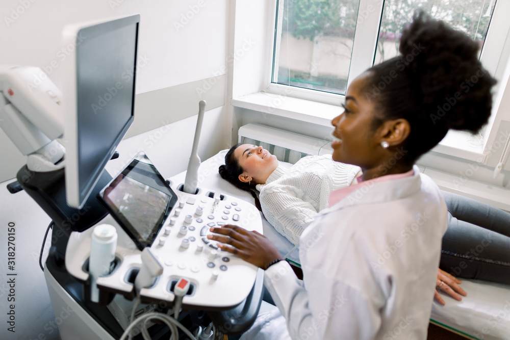 Close-up of African woman doctor sonographer scanning young pregnant ...