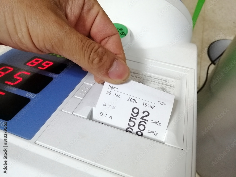 Hand holding a report slip notify blood pressure test results from ...