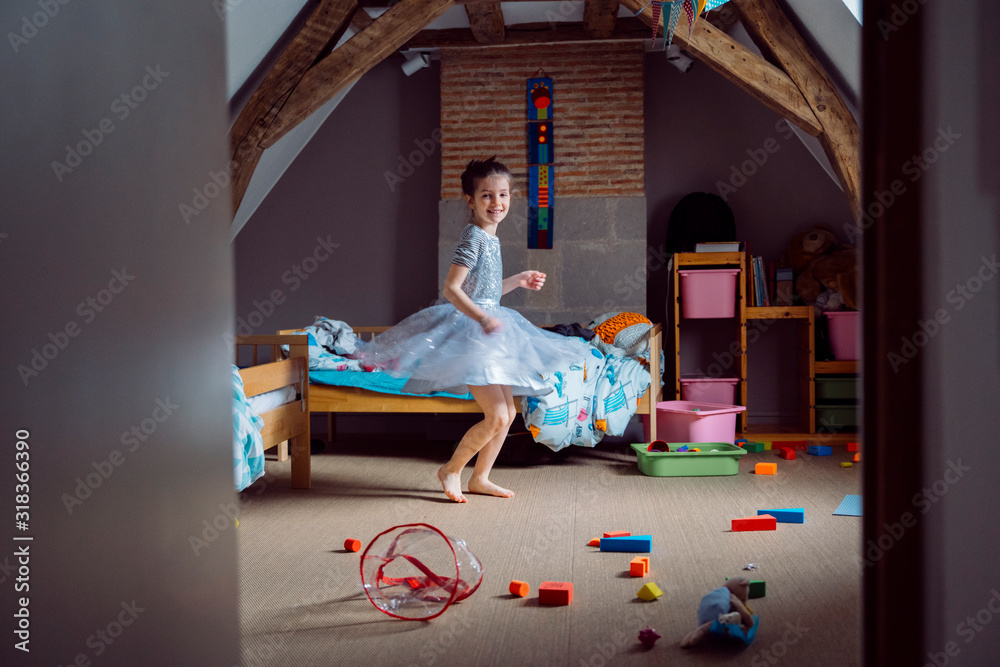 Cheerful little girl organizing presents and toys from birthday party ...