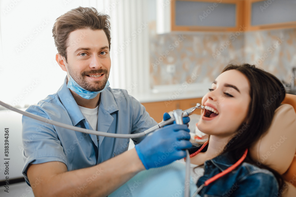 Stomatology doctor treating woman's teeth in modern dentistry clinic ...