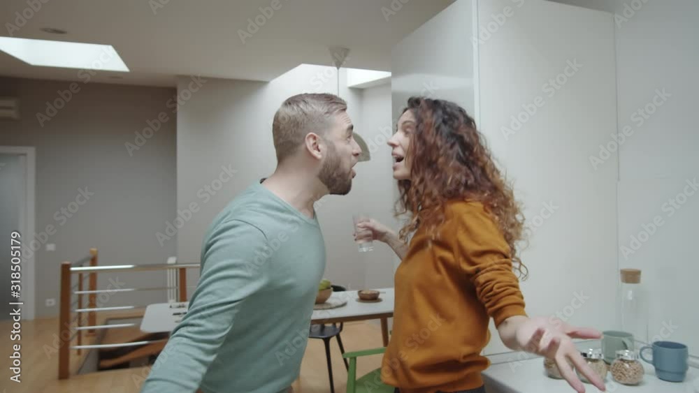 Waist-up shot of emotional young Caucasian boyfriend and girlfriend ...