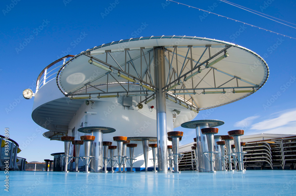 Outdoor pool bar with tables and metal barstools on open deck of ...