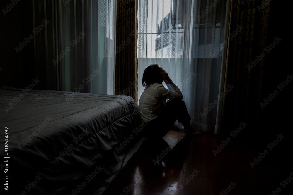 Sad young woman sitting on the bed in the bedroom, People with ...
