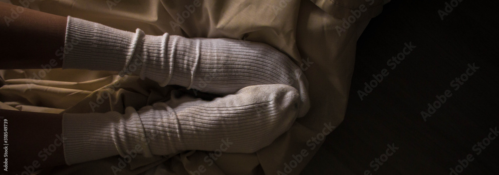 women's feet in white stockings white socks on the bed style background ...