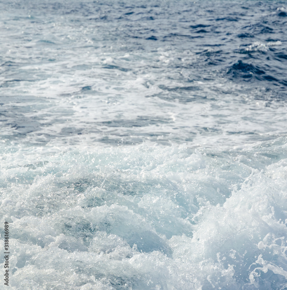 Water splashes and ripples from behind a boat in a blue ocean. boat ...