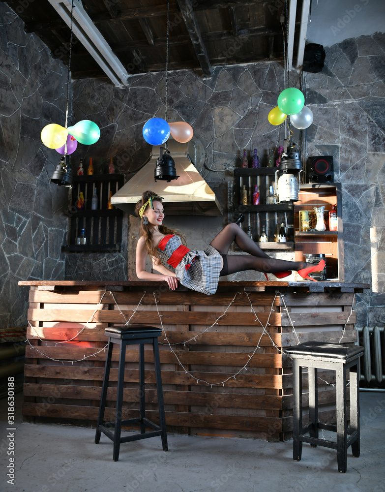 beautiful pin-up girl in a gray-red dress lies on a bar table Stock ...
