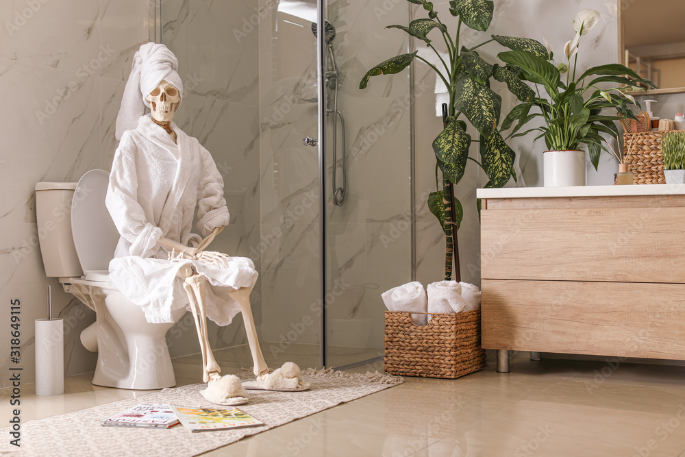 Skeleton in bathrobe sitting on toilet bowl Stock Photo | Adobe Stock